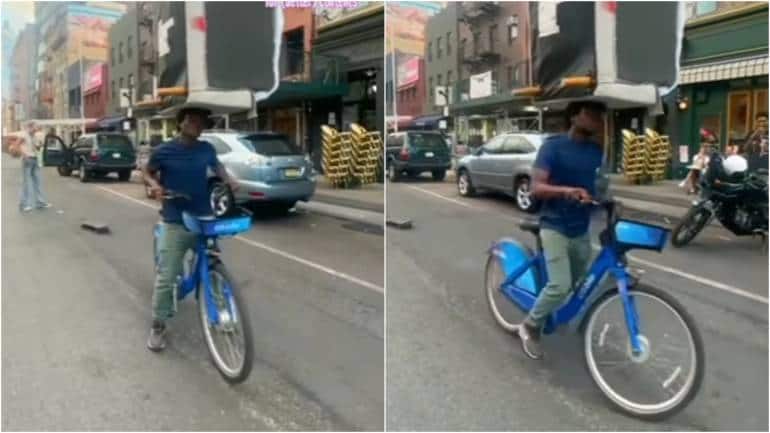 Man balances giant couch on his head while riding a bicycle in New York ...