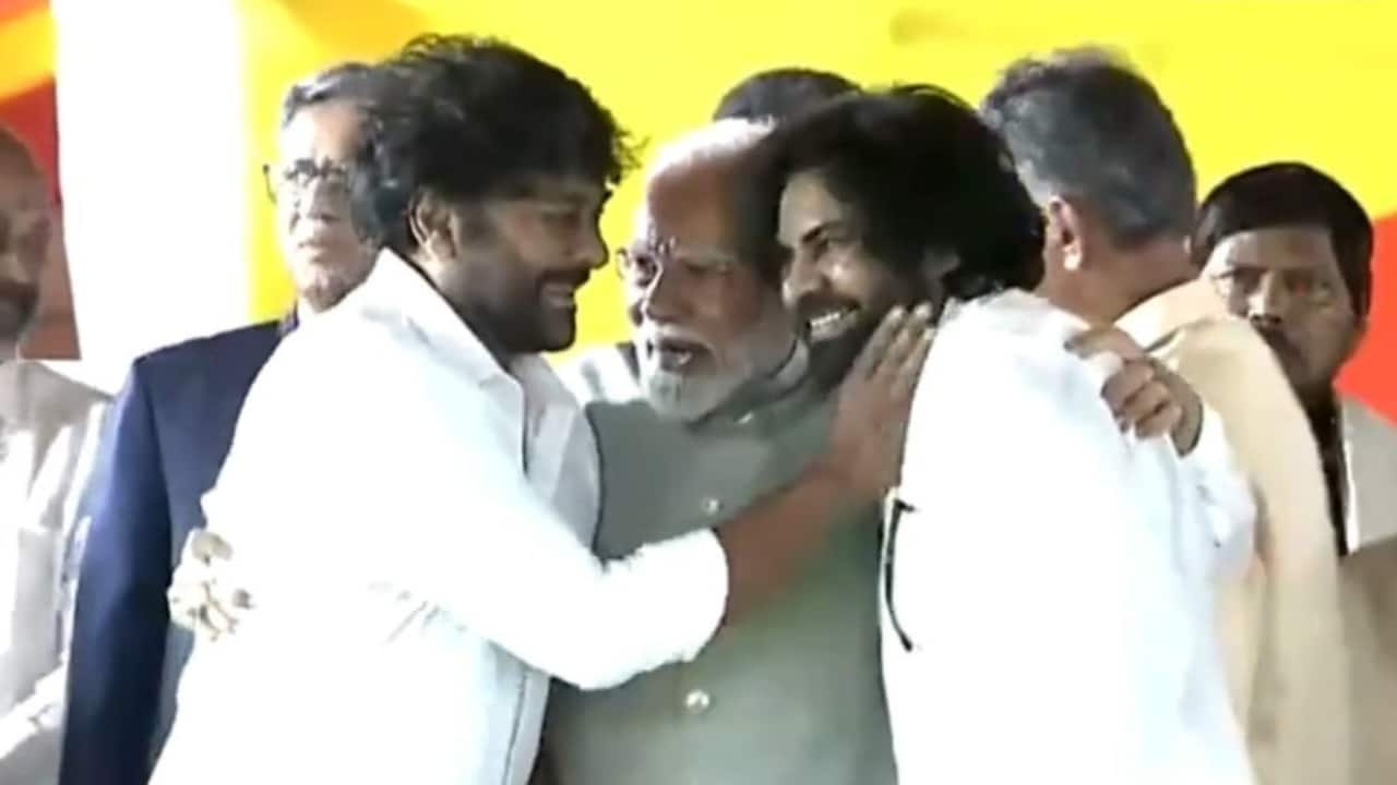 Telugu superstar Chiranjeevi and politician Pawan Kalyan hug PM Narendra Modi at the swearing in ...
